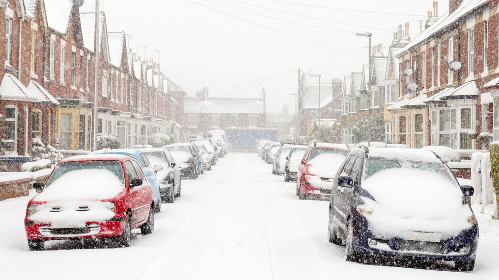 A street is covered in a blanket of snow.